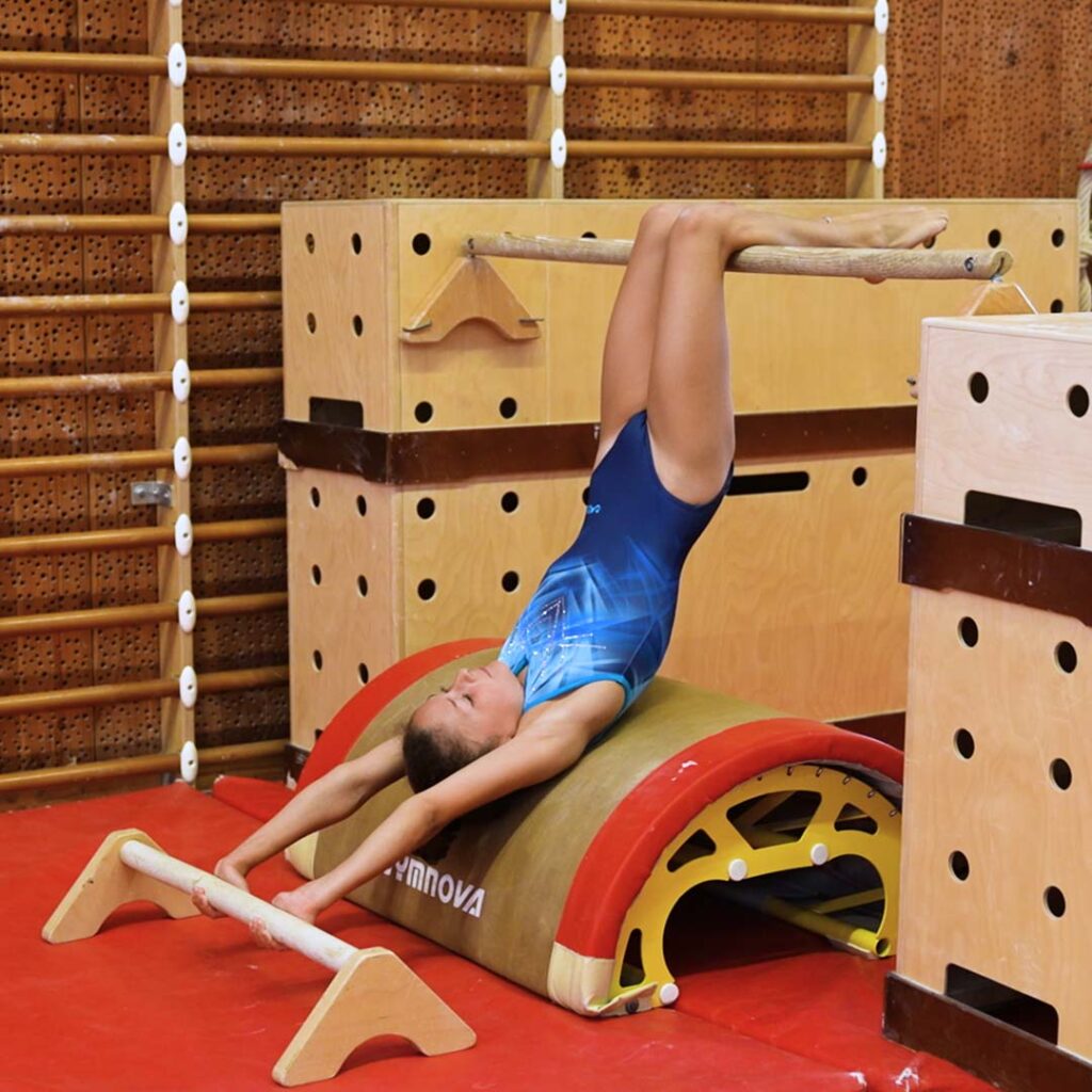 Training guide to the swing with bent legs on uneven bars